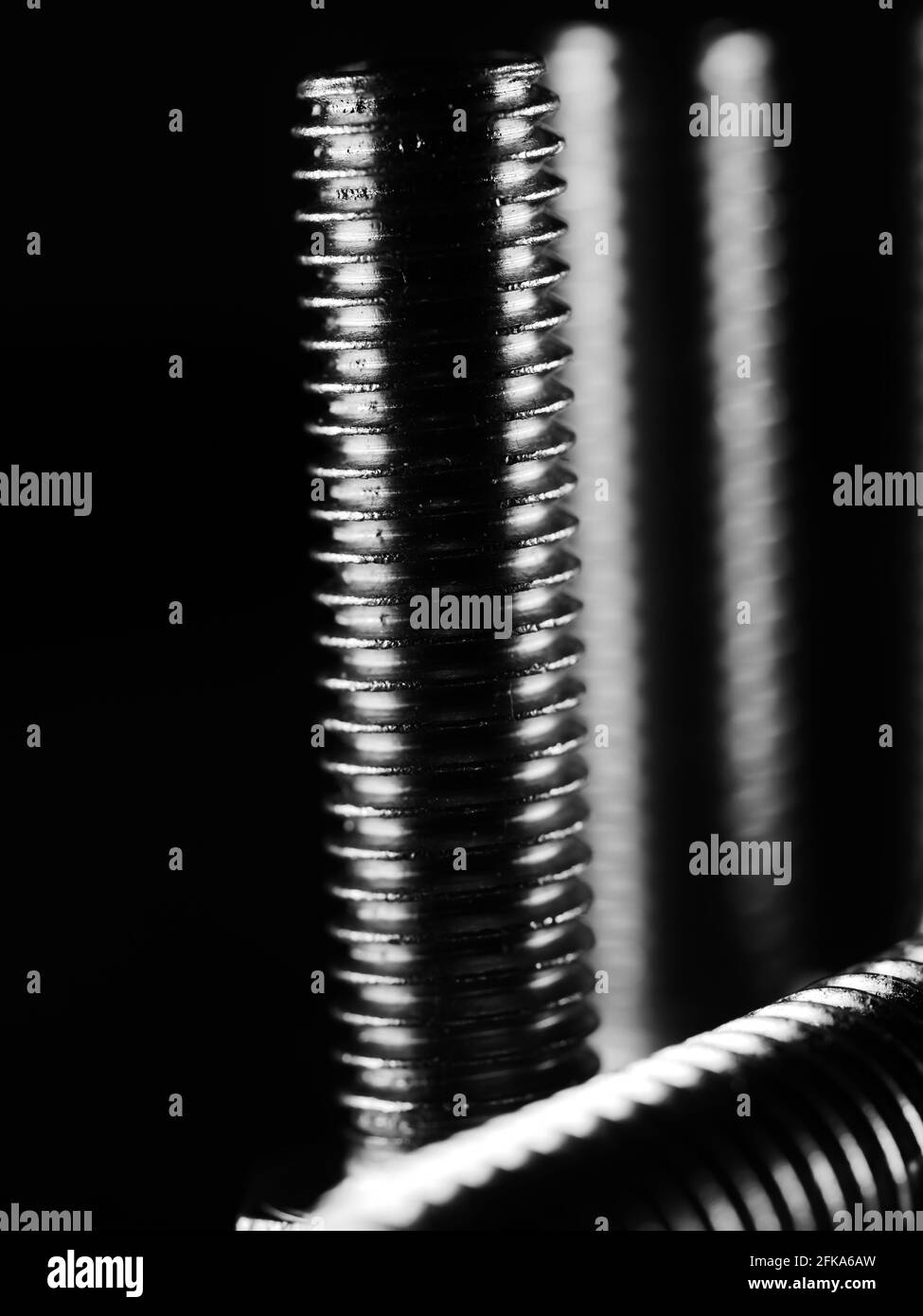 Vertical shot of metal screw threads isolated on the black background ...