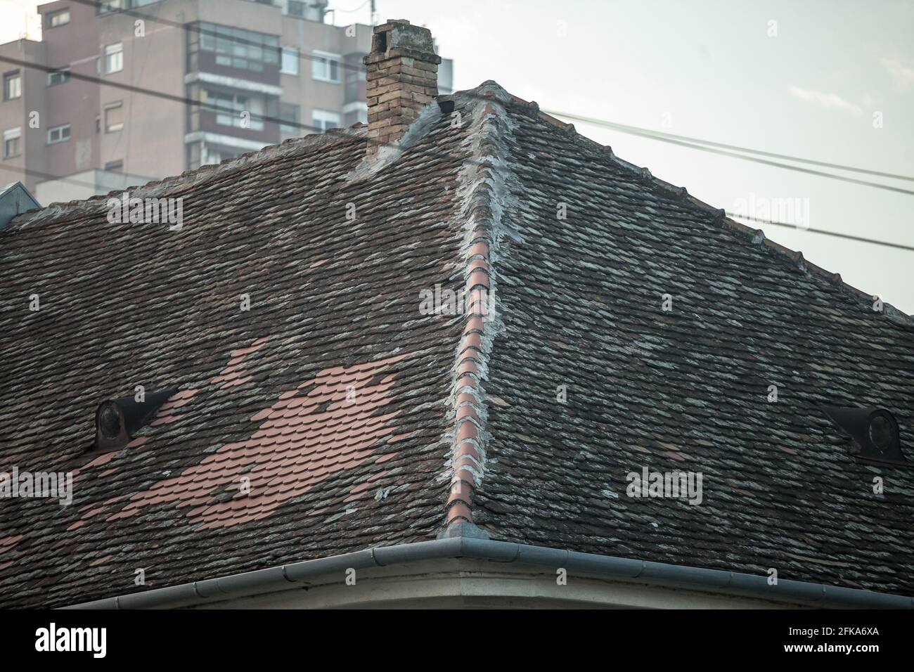 Picture of an old roof, partially repaired, but mainly in poor ...