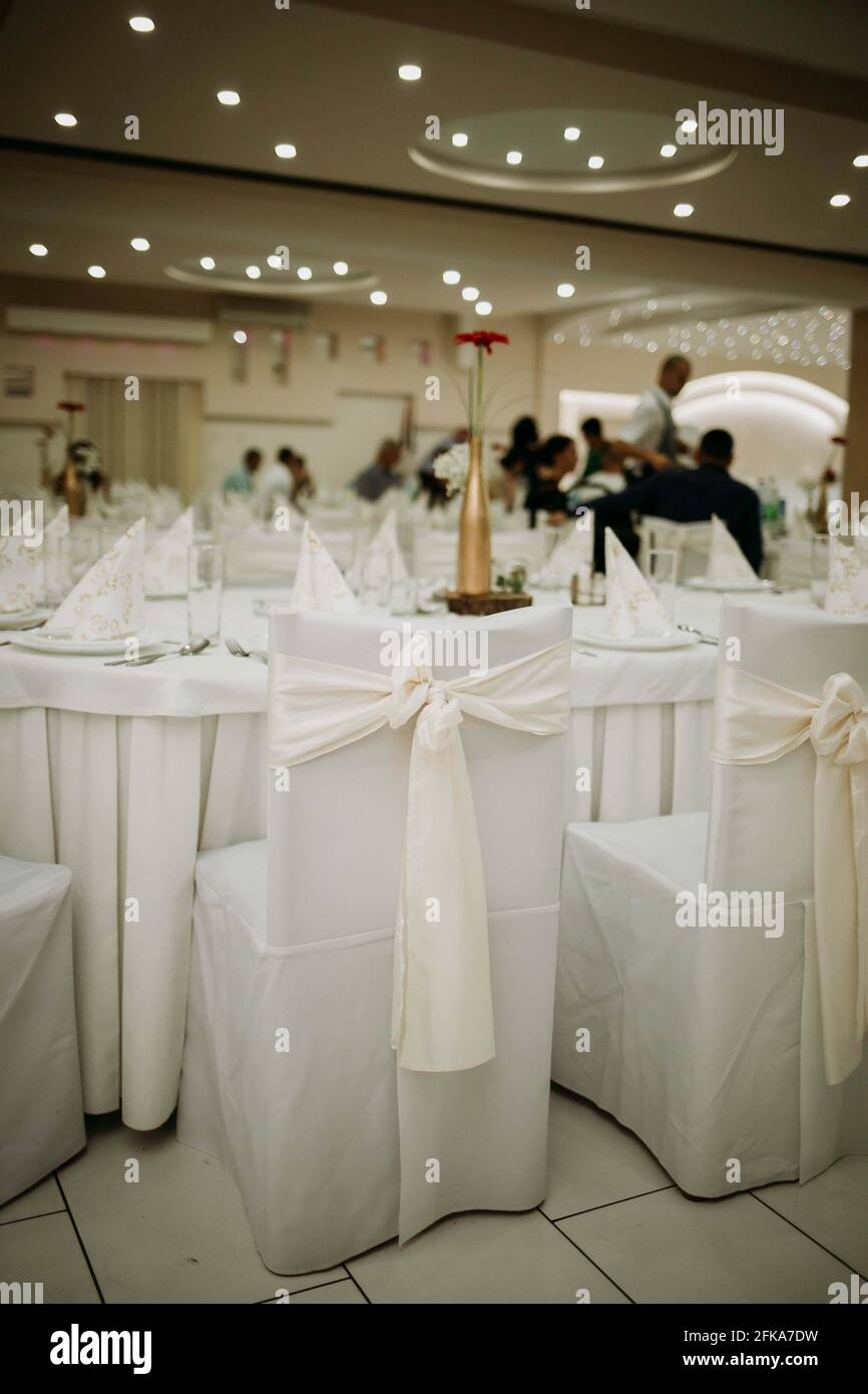 Vertical shot of prepared and decorated tables for an event in a ...