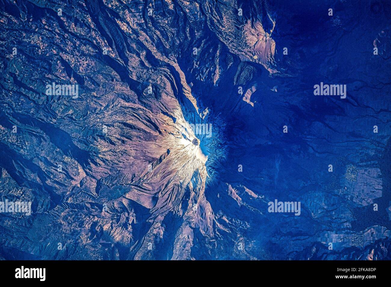Volcano crater on snowcapped mountain. For NASA usage guidance: https ...