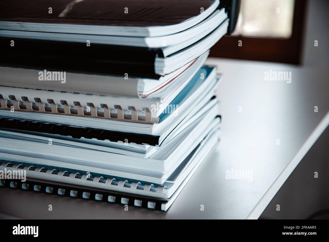 Stack of reports lies on a desk ready for review Stock Photo - Alamy