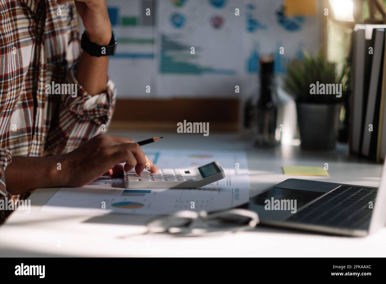 Business accounting concept, A man using calculator with computer ...