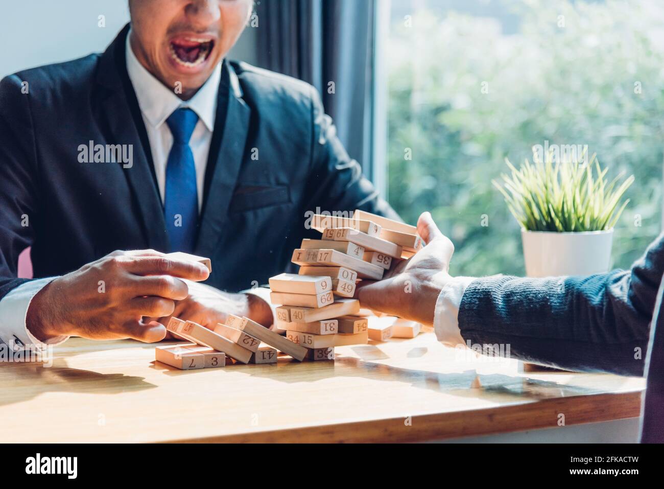 Business man strategy risk pulling block wood tower and have one ...