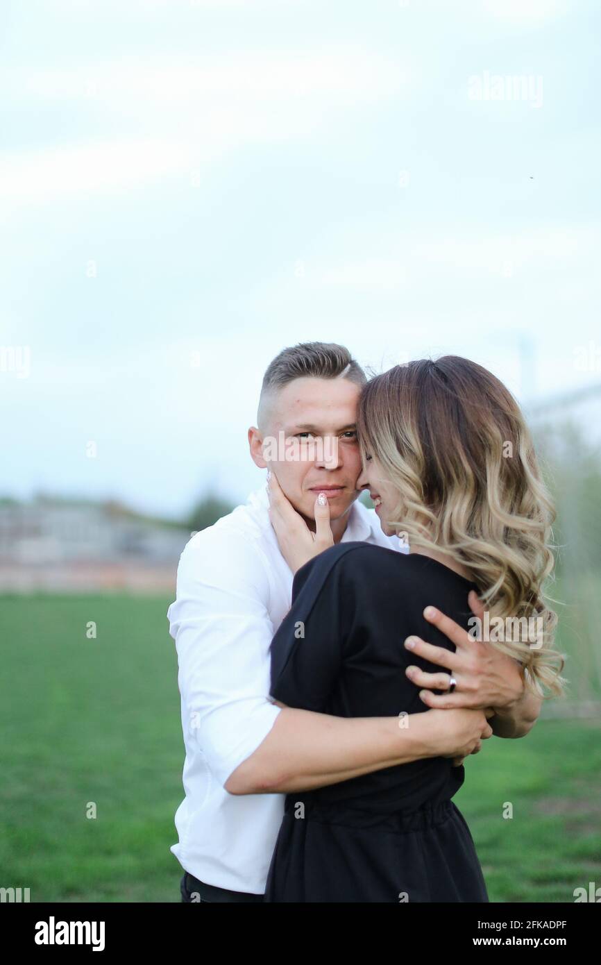 Portrait of caucasian man hugging back view girl on football field ...