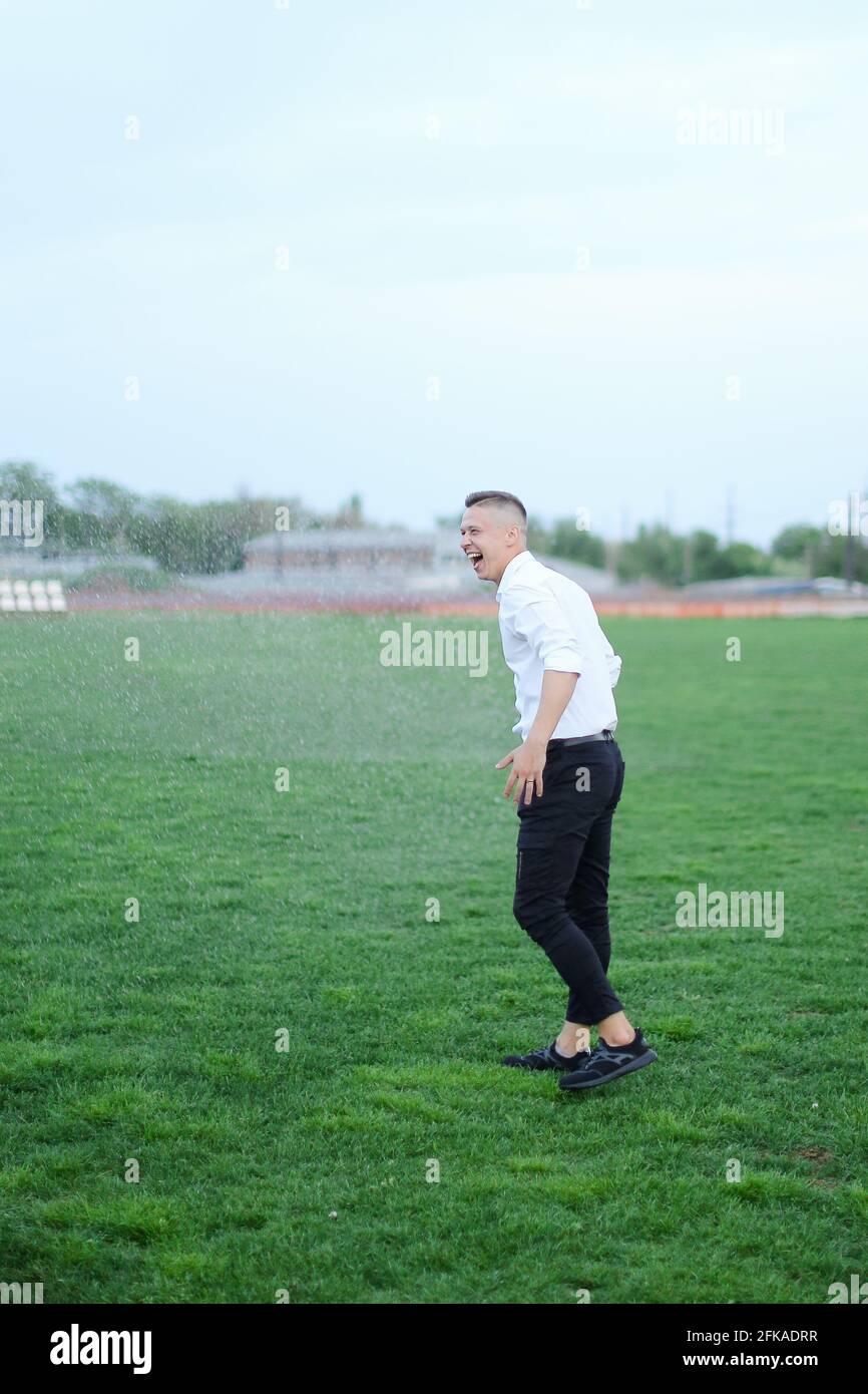 European boy standing on sprinkling football field Stock Photo - Alamy