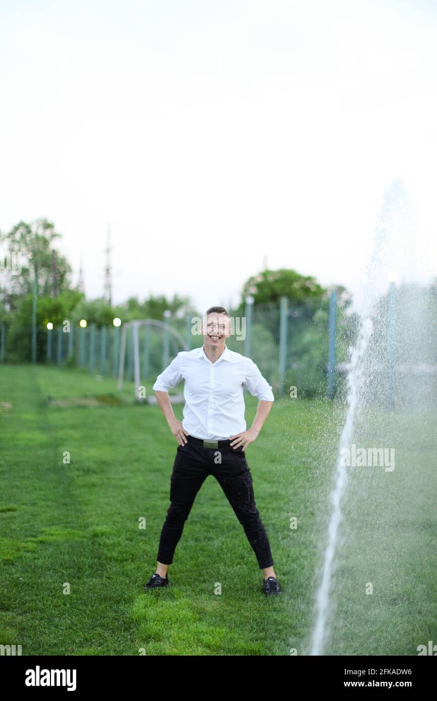 European boy standing on sprinkling football field near water jet Stock ...