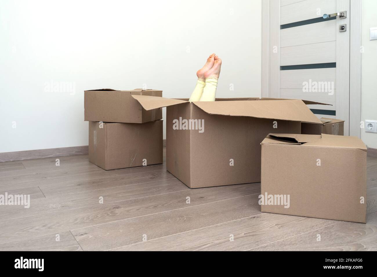 baby's feet are sticking out of the cardboard box. moving to a new ...