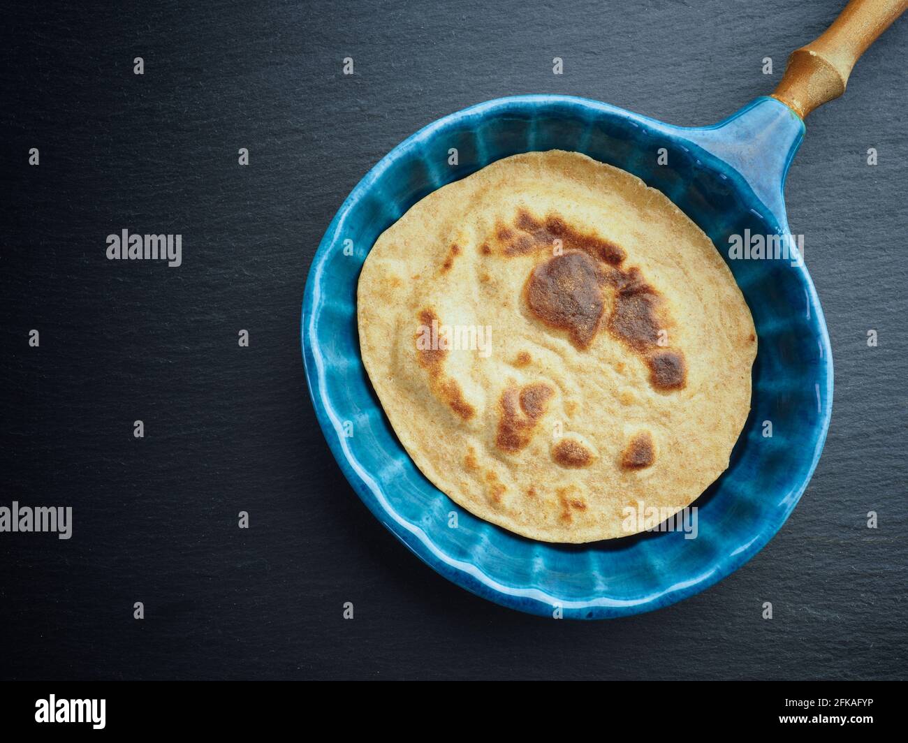 Delicious organic spelt pancake in a blue stoneware pan, healthy food ...