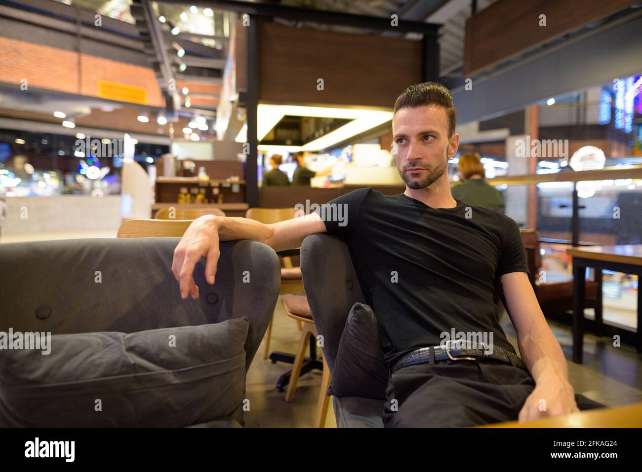 Portrait of handsome man sitting at coffee shop while thinking Stock ...