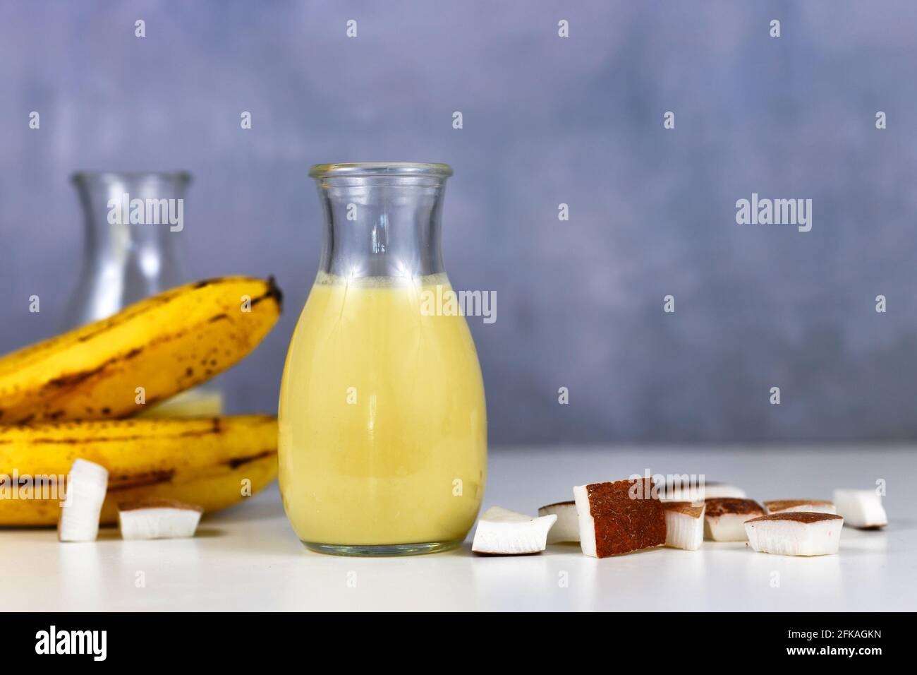 Yellow banana and coconut smoothie drink in jar Stock Photo - Alamy