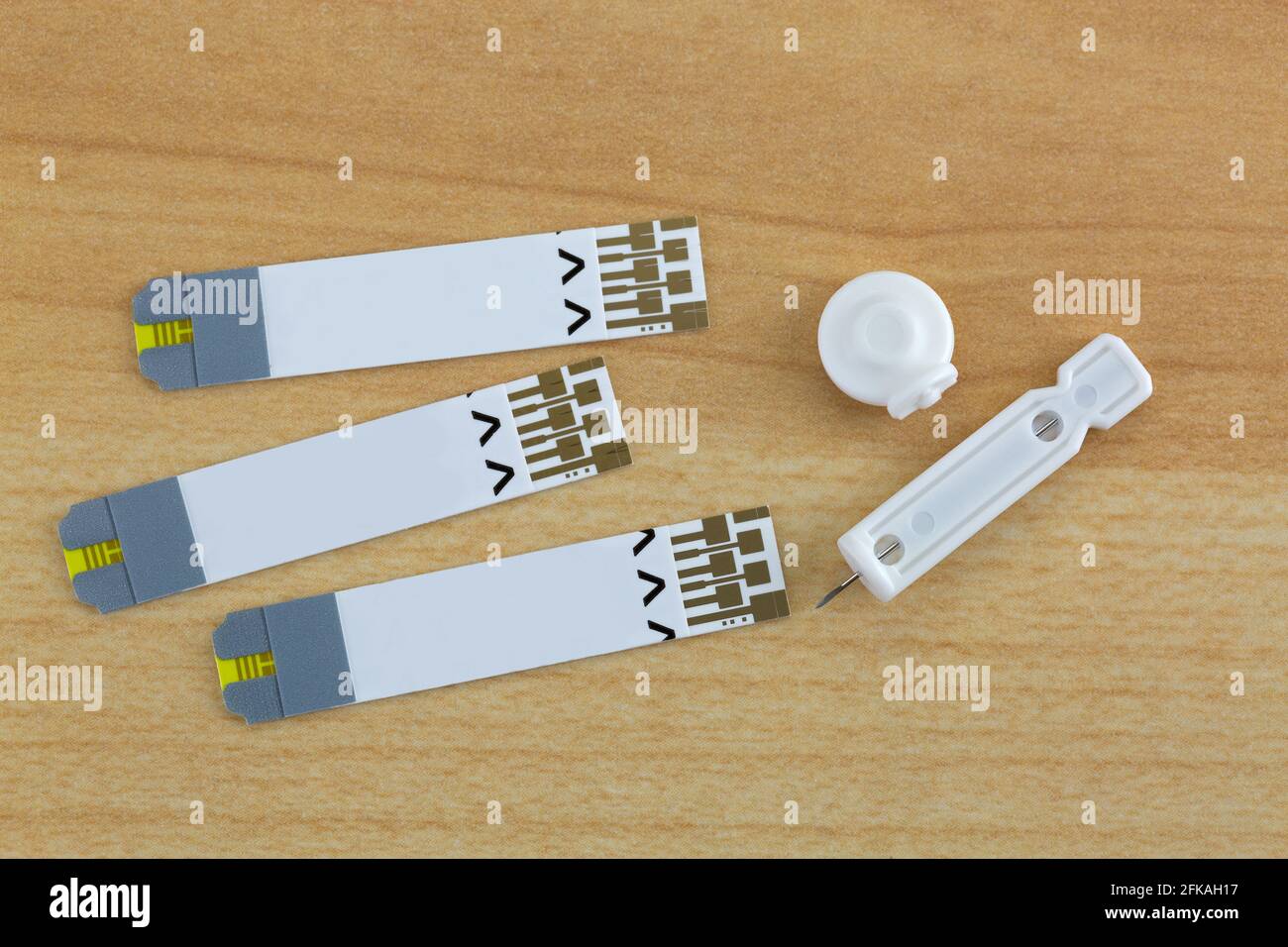 Closeup of Blood Glucose test strip with lancets, lancing pen device on ...