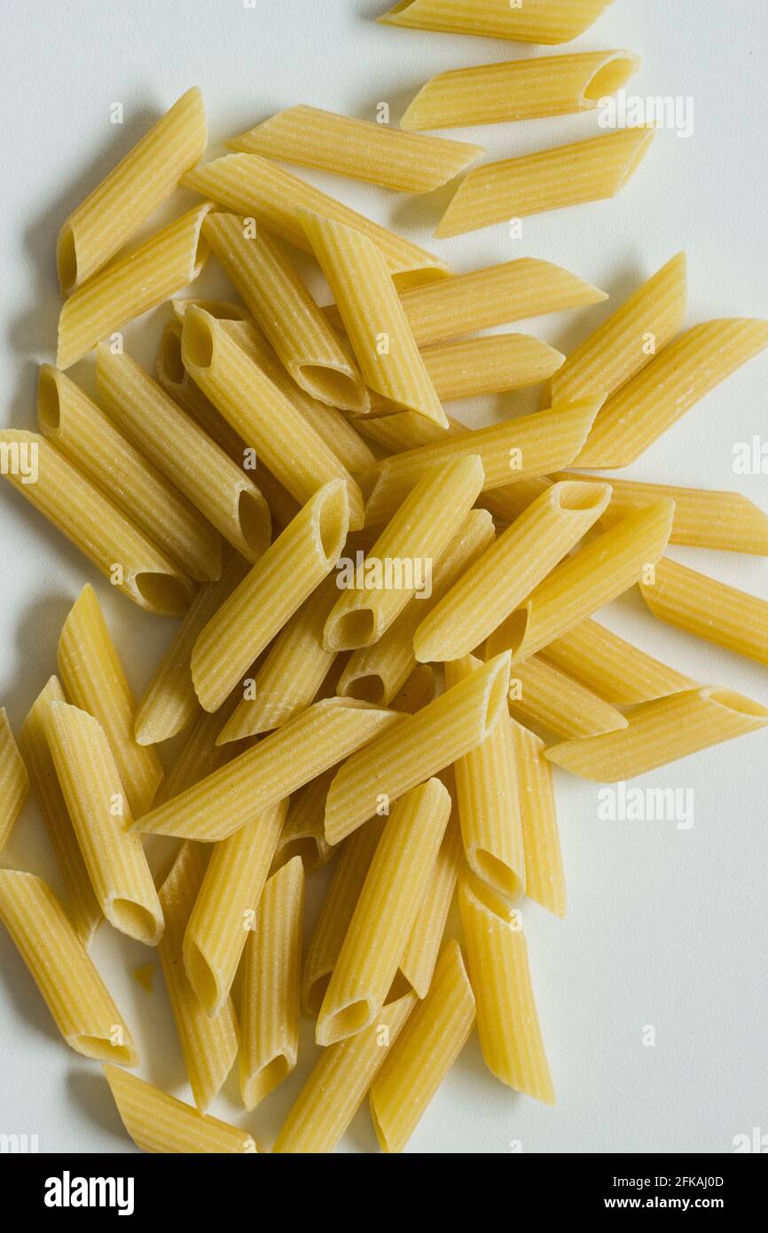 Stack of uncooked penne pasta isolated on white background; Italian ...