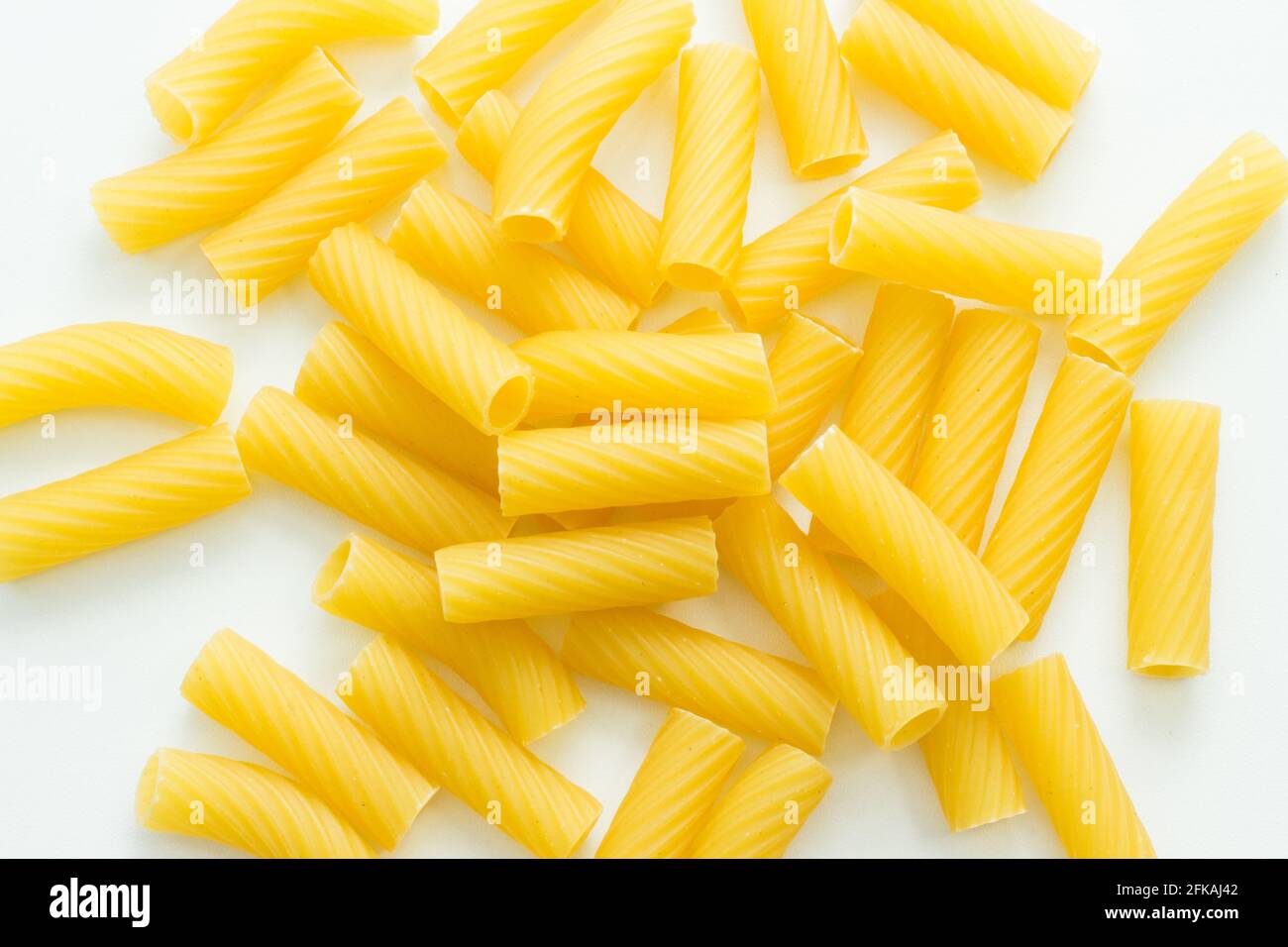 Stack of uncooked tortiglioni on white background Stock Photo - Alamy
