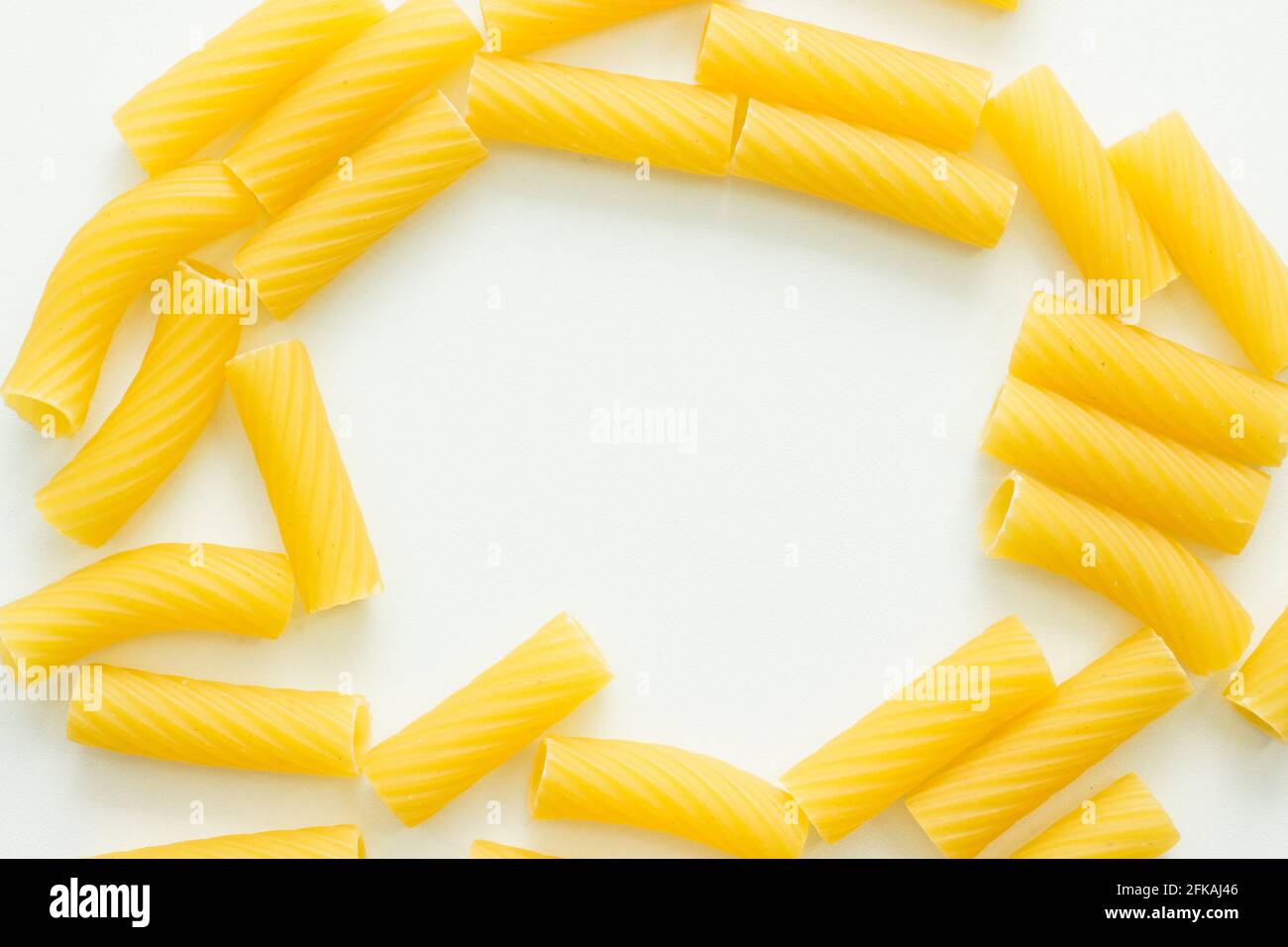 Tortiglioni noodles in a circle on white background with copy space ...