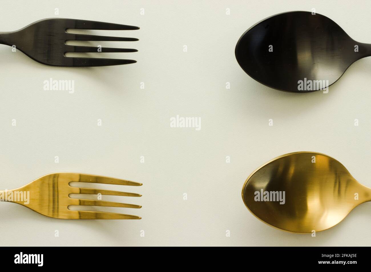 Golden and black fork, knife and spoon on white background; cutlery ...