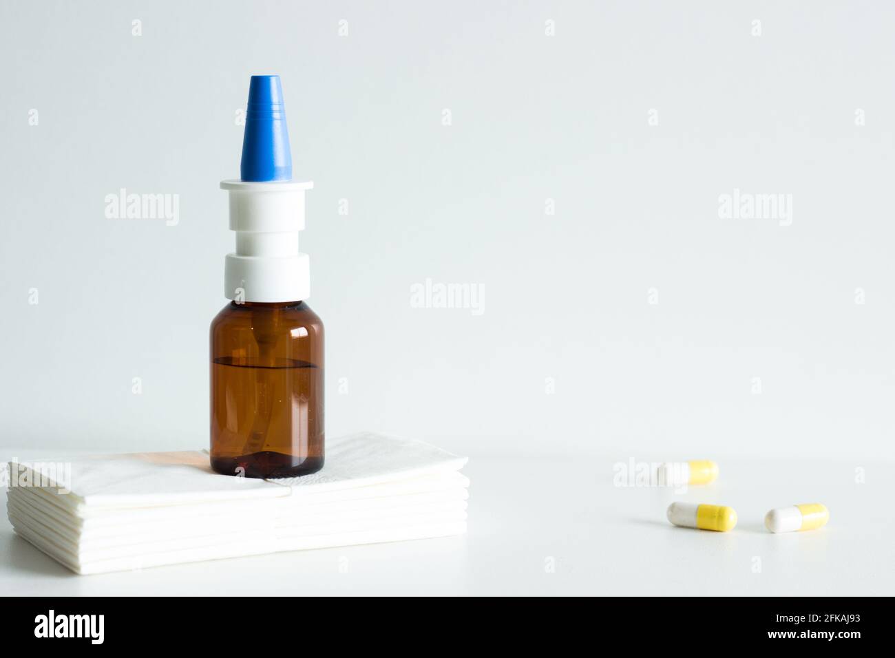 Nasal spray and yellow and white pills on the side Stock Photo - Alamy
