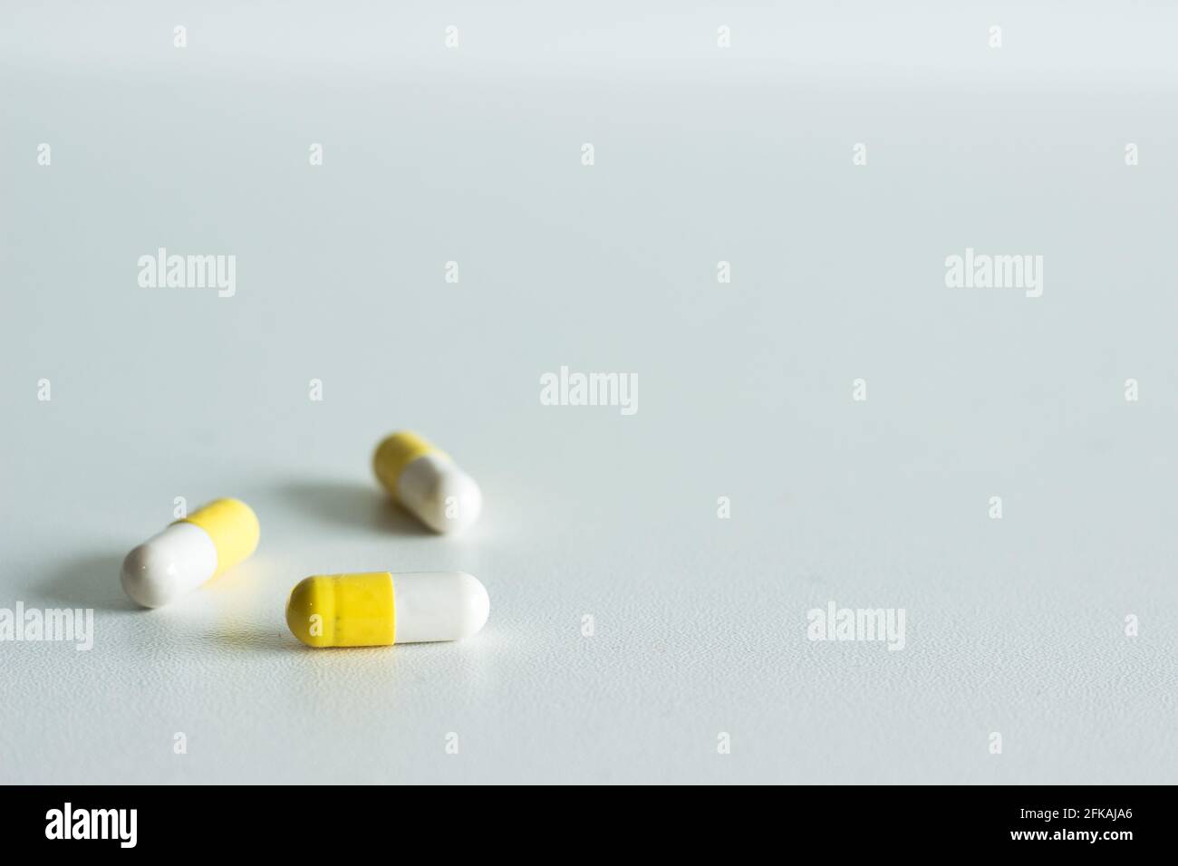 Yellow and white pills isolated on white background; medicine; cold and ...