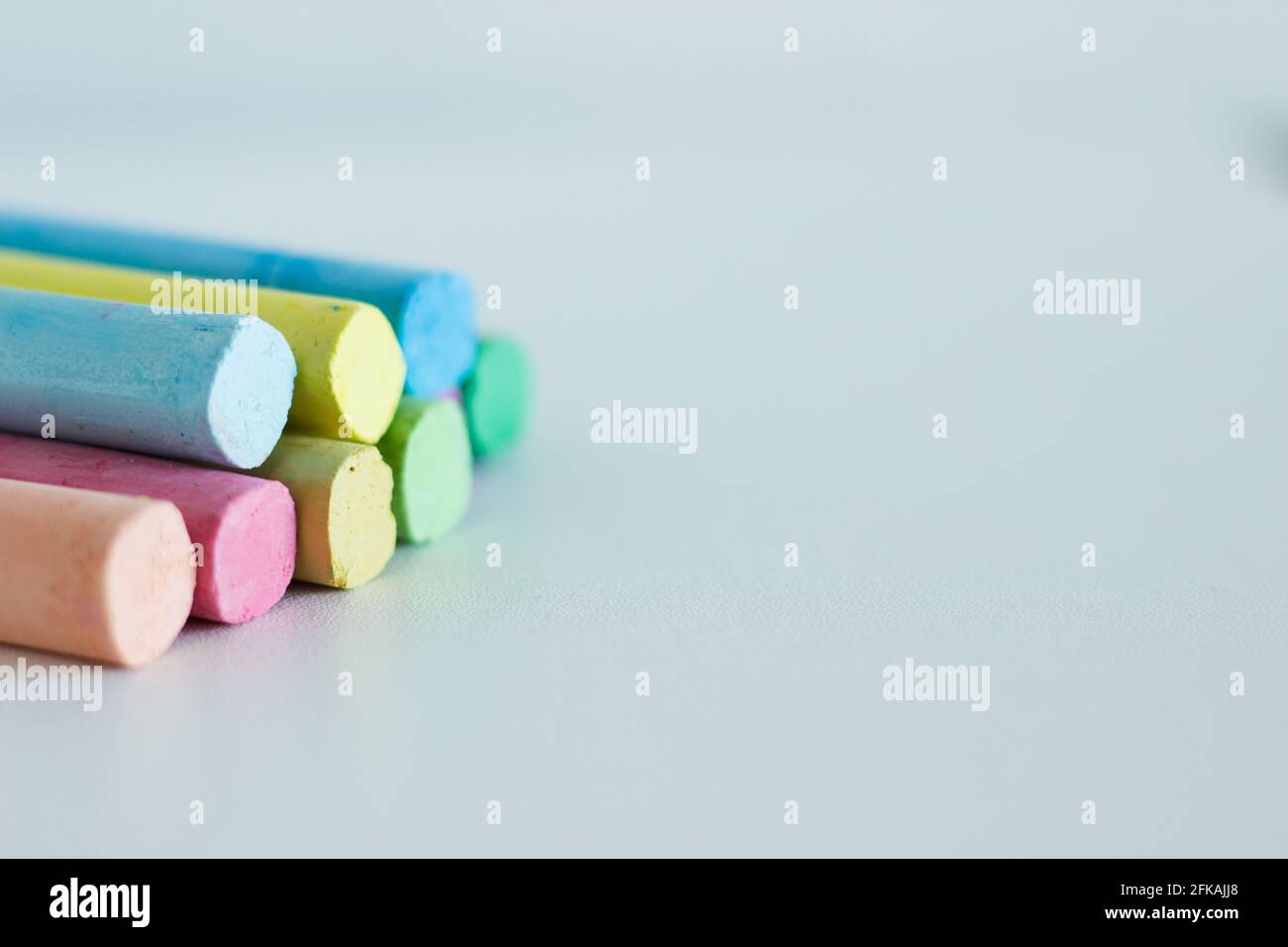 Close up of a row of colorful chalks isolated on white background with ...