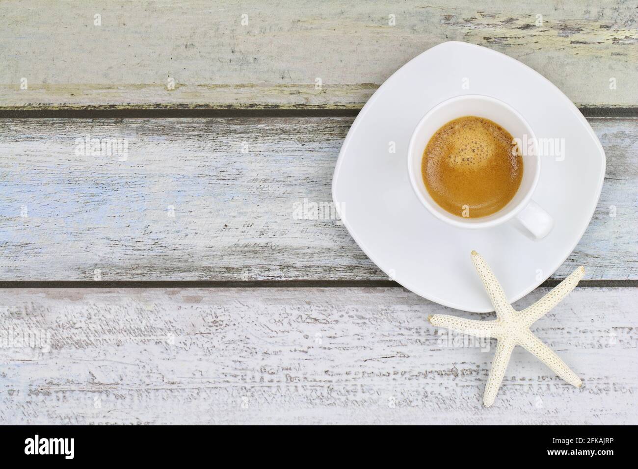Star fish on freshly brewed espresso coffee on blue green wooden ...