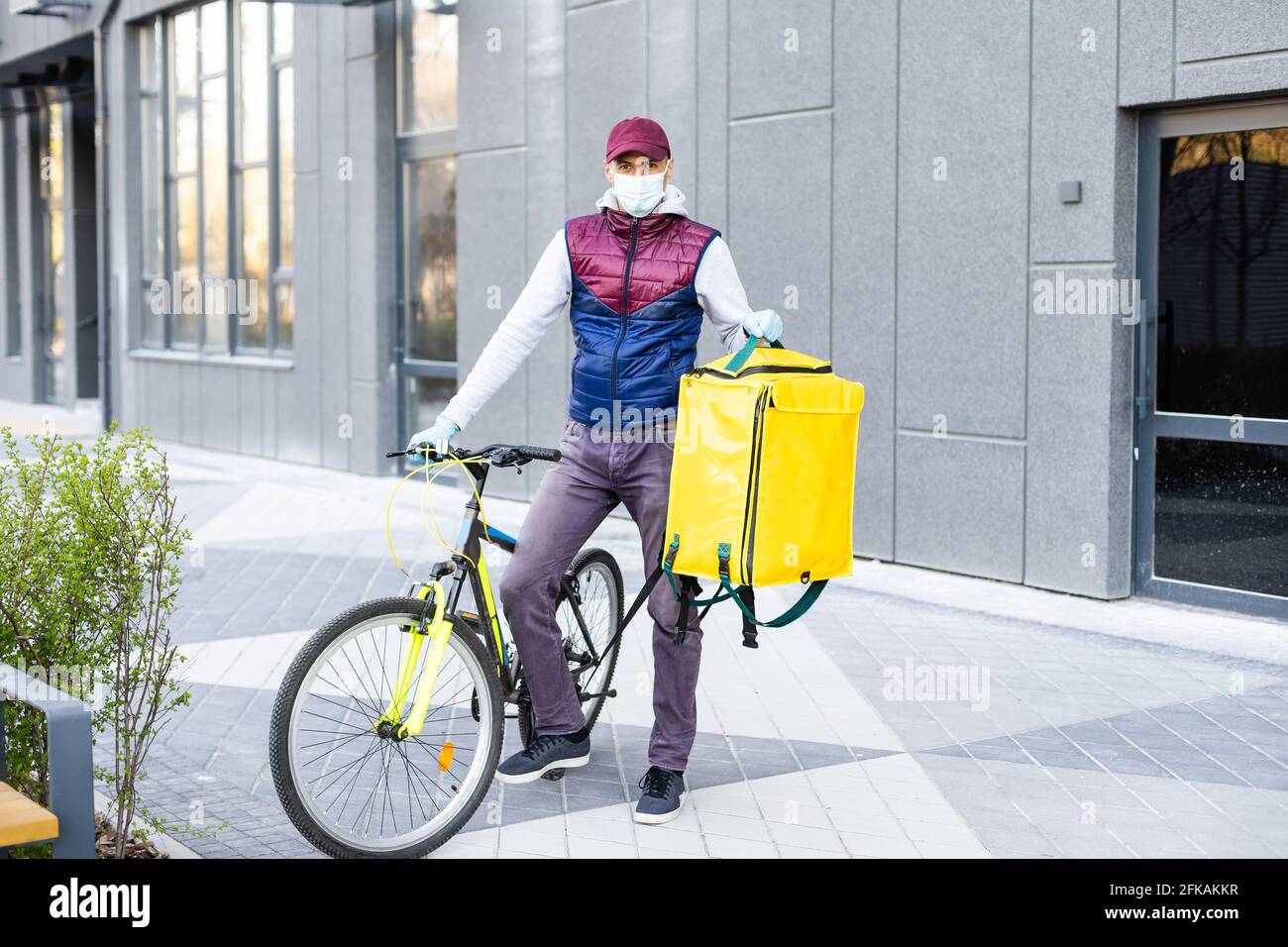 Delivery Man standing with yellow thermo backpack for food delivery ...