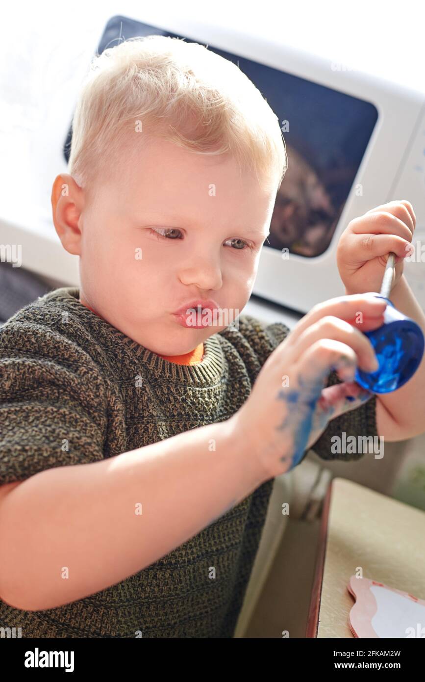A three-year-old boy paints with gouache coloring, leisure and child ...