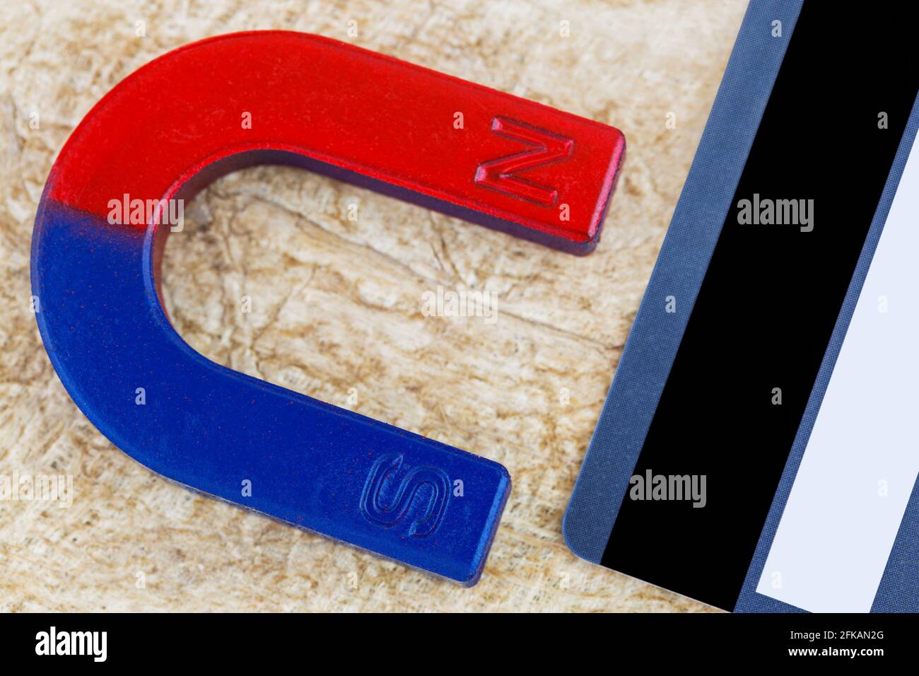 Closeup of magnet pulling credit card on fiber paper background Stock ...