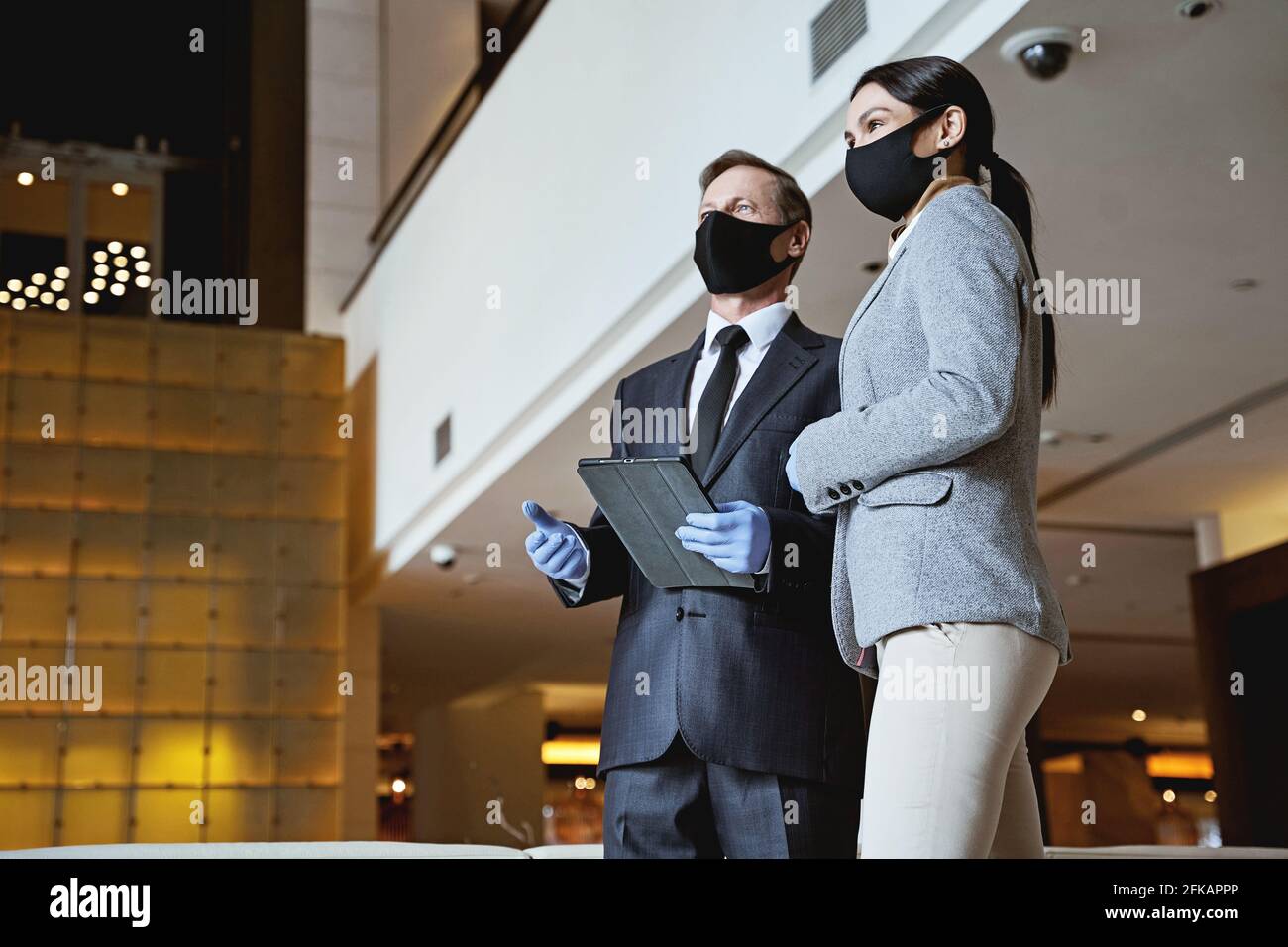 Professional hotel administrator showing everything to younger ...