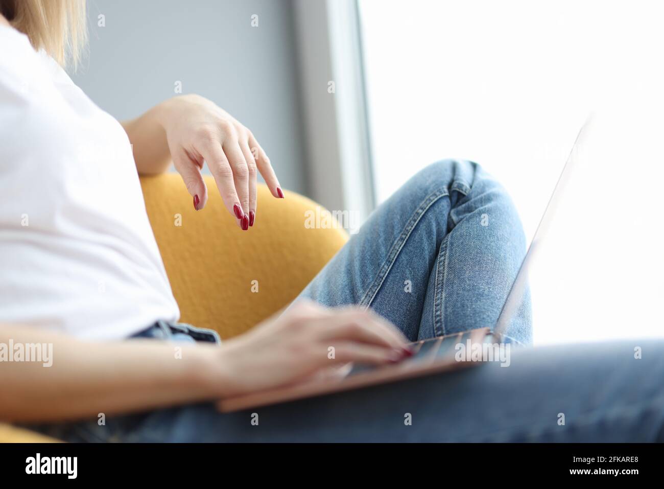 Woman sitting on armchair and typing on laptop keyboard closeup Stock ...