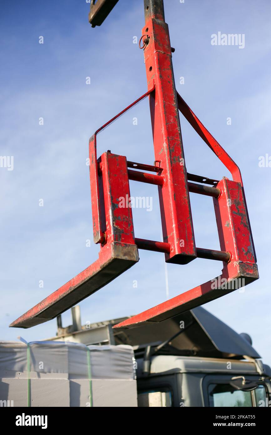 Unloading building blocks from a truck using a crane. Hydraulic ...