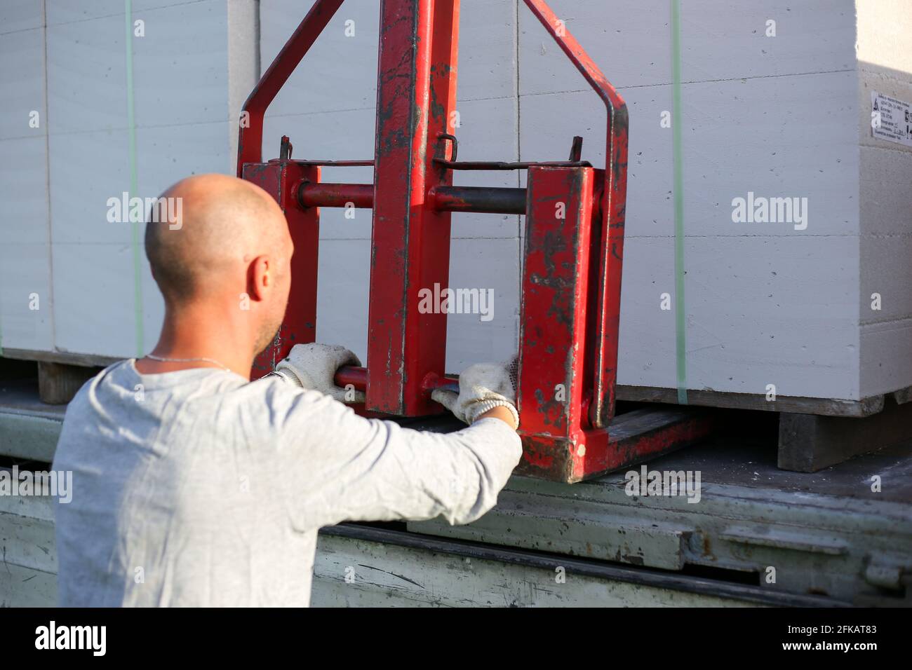 Unloading building blocks from a truck using a crane. Hydraulic ...