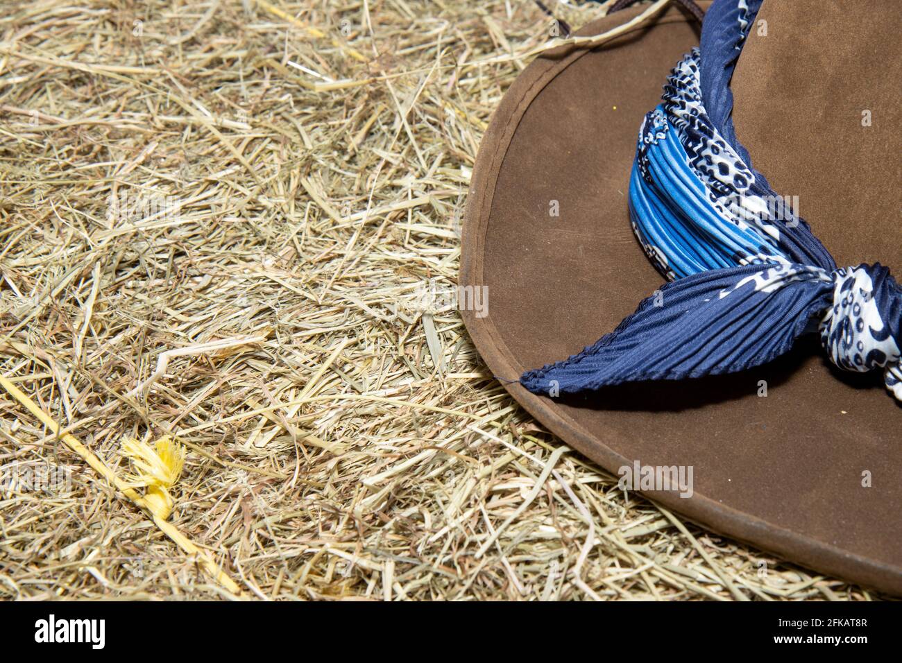 A straw bail background texture with a brown cowboy hat resting on the ...