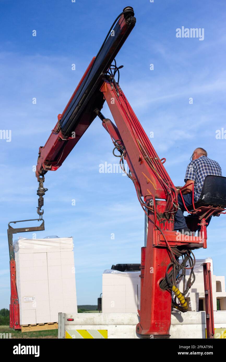 Unloading building blocks from a truck using a crane. Hydraulic ...
