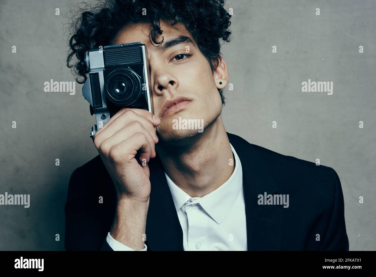 stylish man with camera in hand photography studio curls model portrait ...