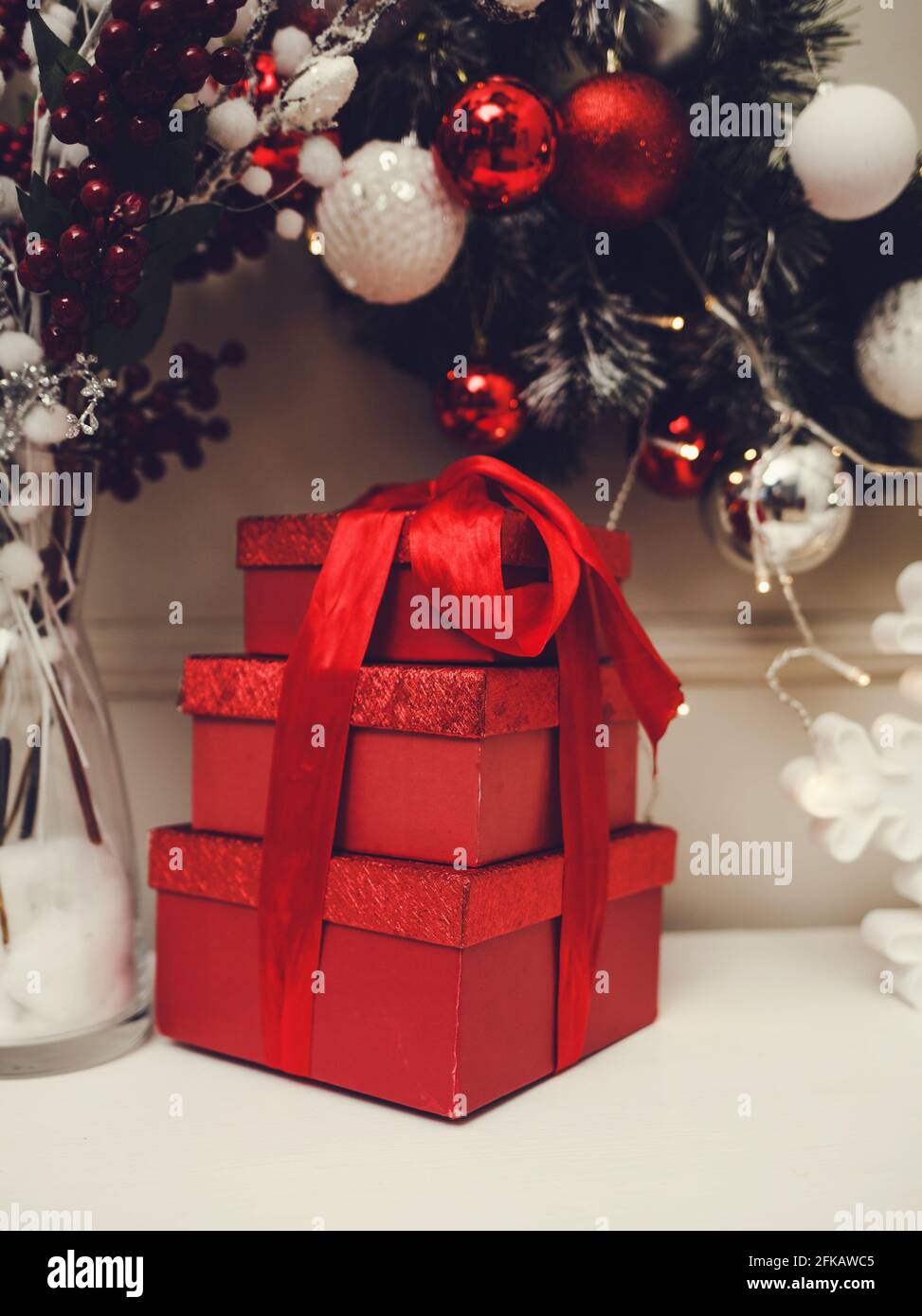 Gift boxes with big red ribbon on background of twinkling lights ...