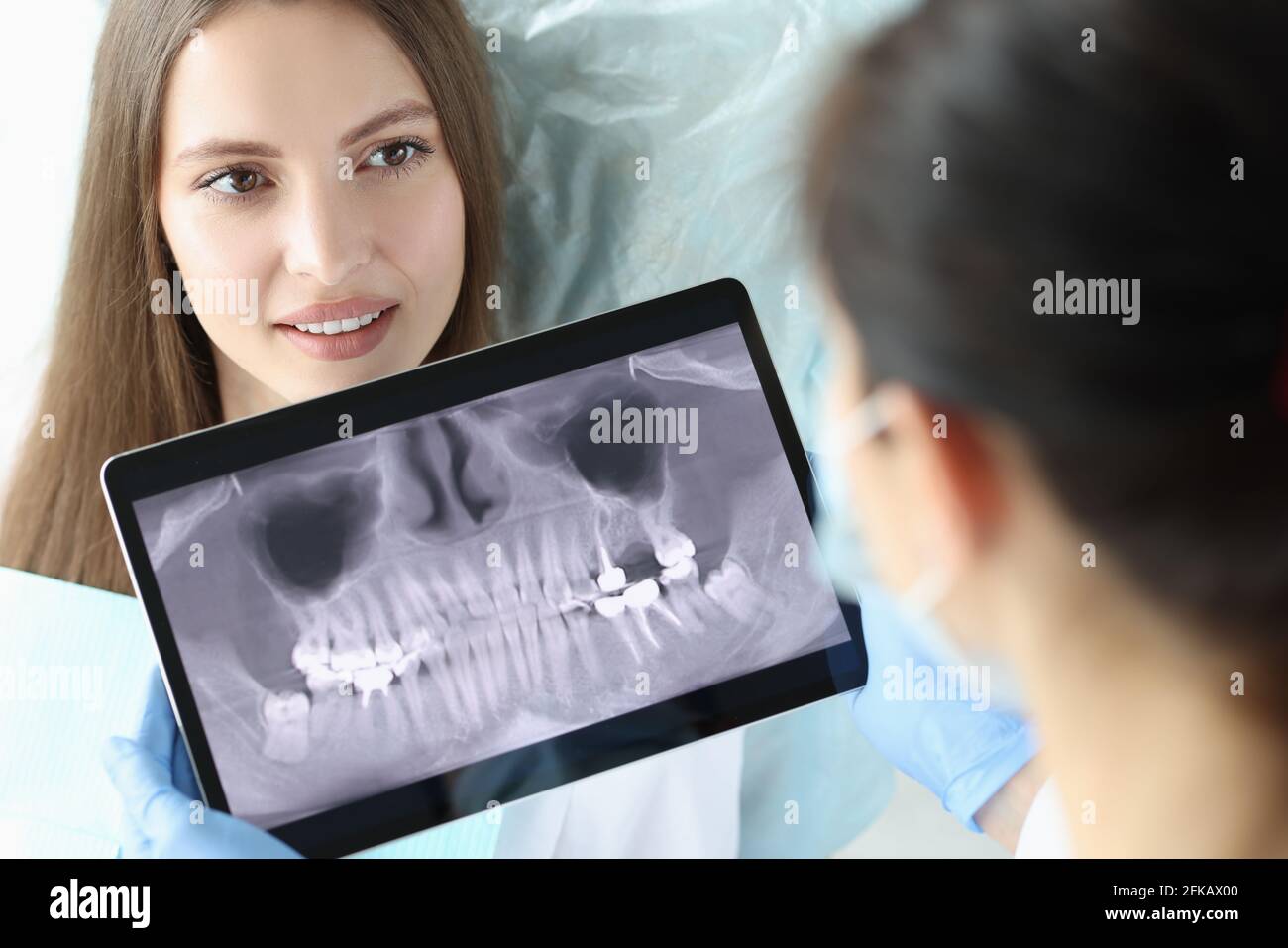 Dentist doctor holding digital tablet with teeth xray in front of ...