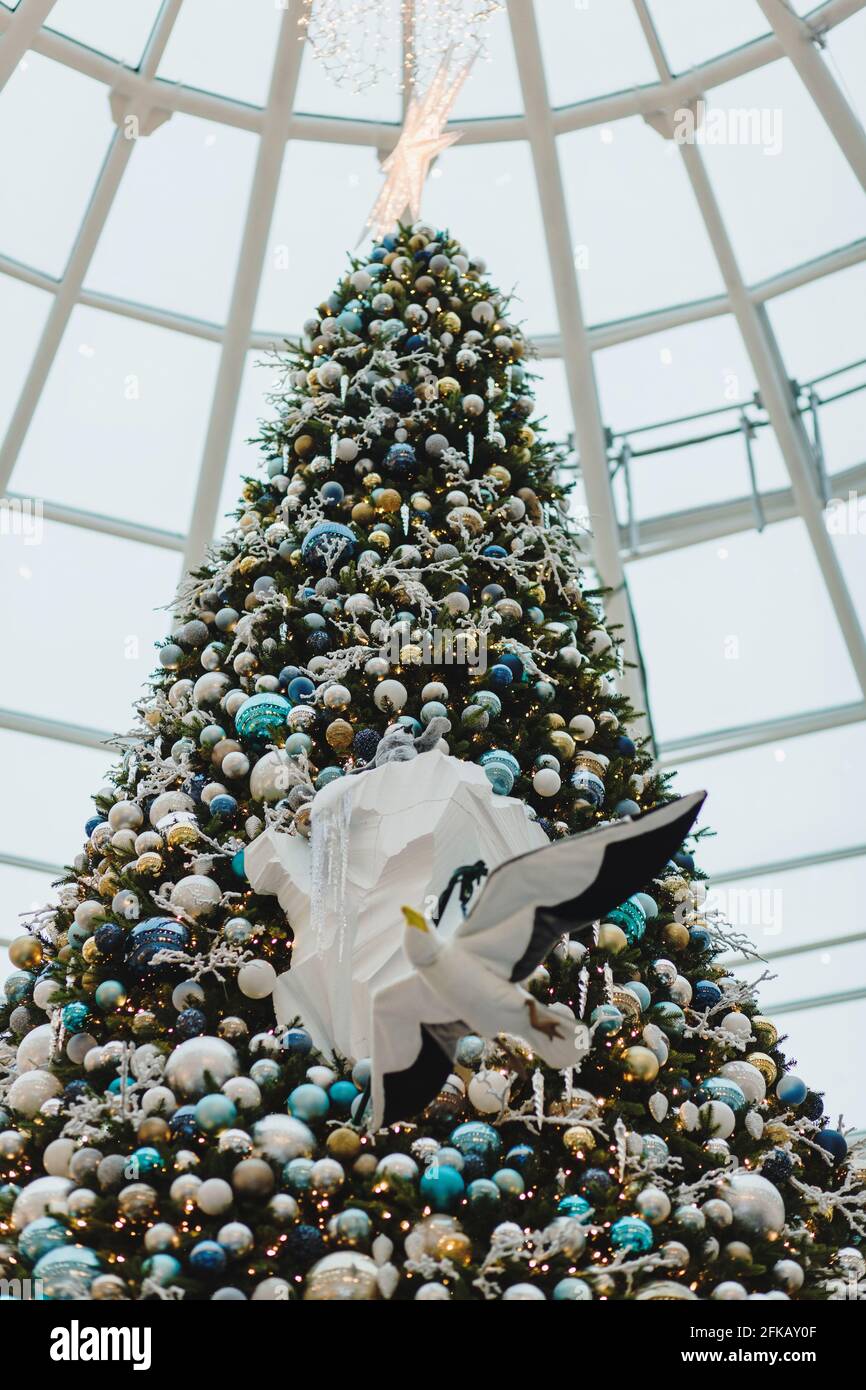 tall Christmas tree with bright star in shopping Mall Stock Photo - Alamy