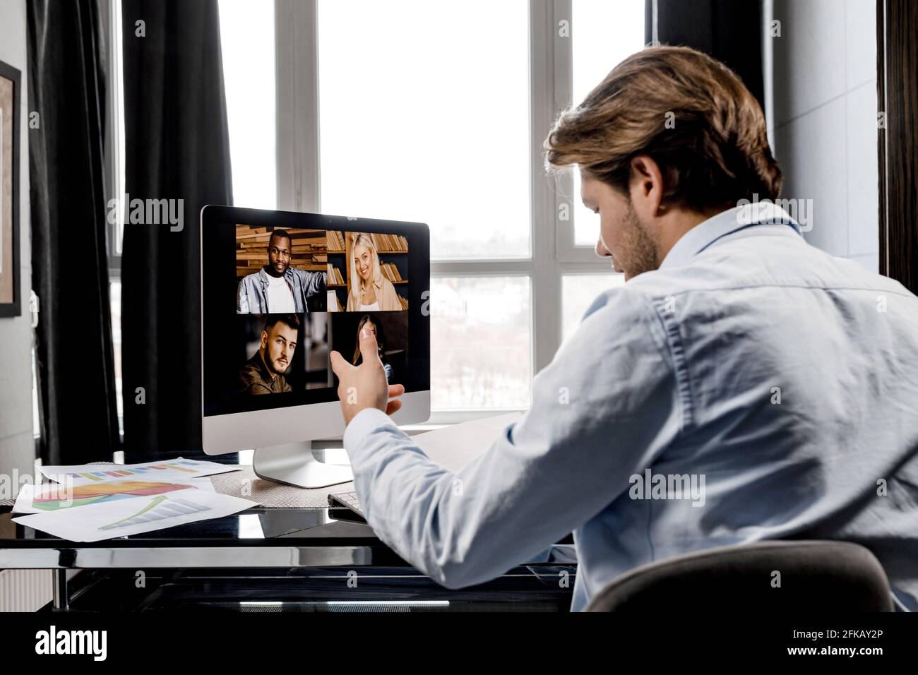 Back view portrait of serious male employee talking with colleagues on ...