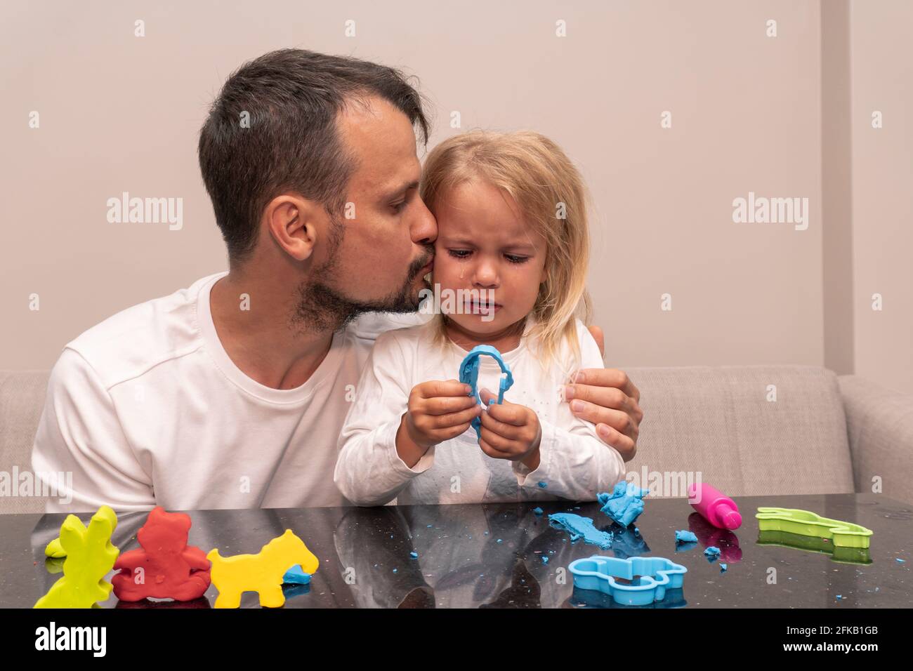 Young caucasian dad embraces and kisses his crying sad child Stock ...