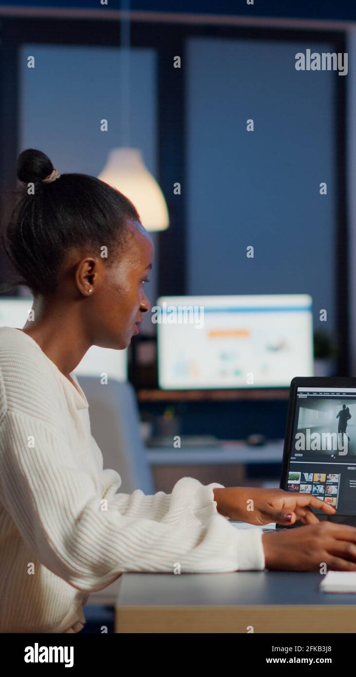 Black video editor working overtime at new project editing audio film ...