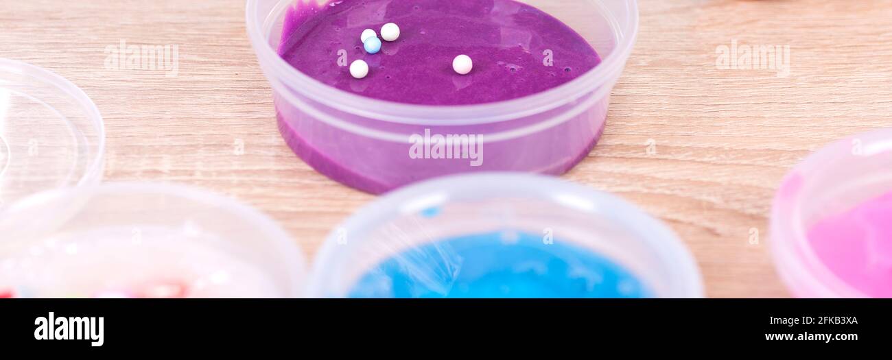 A lot of slimes on the table in jars. Putting the balls into the slime ...