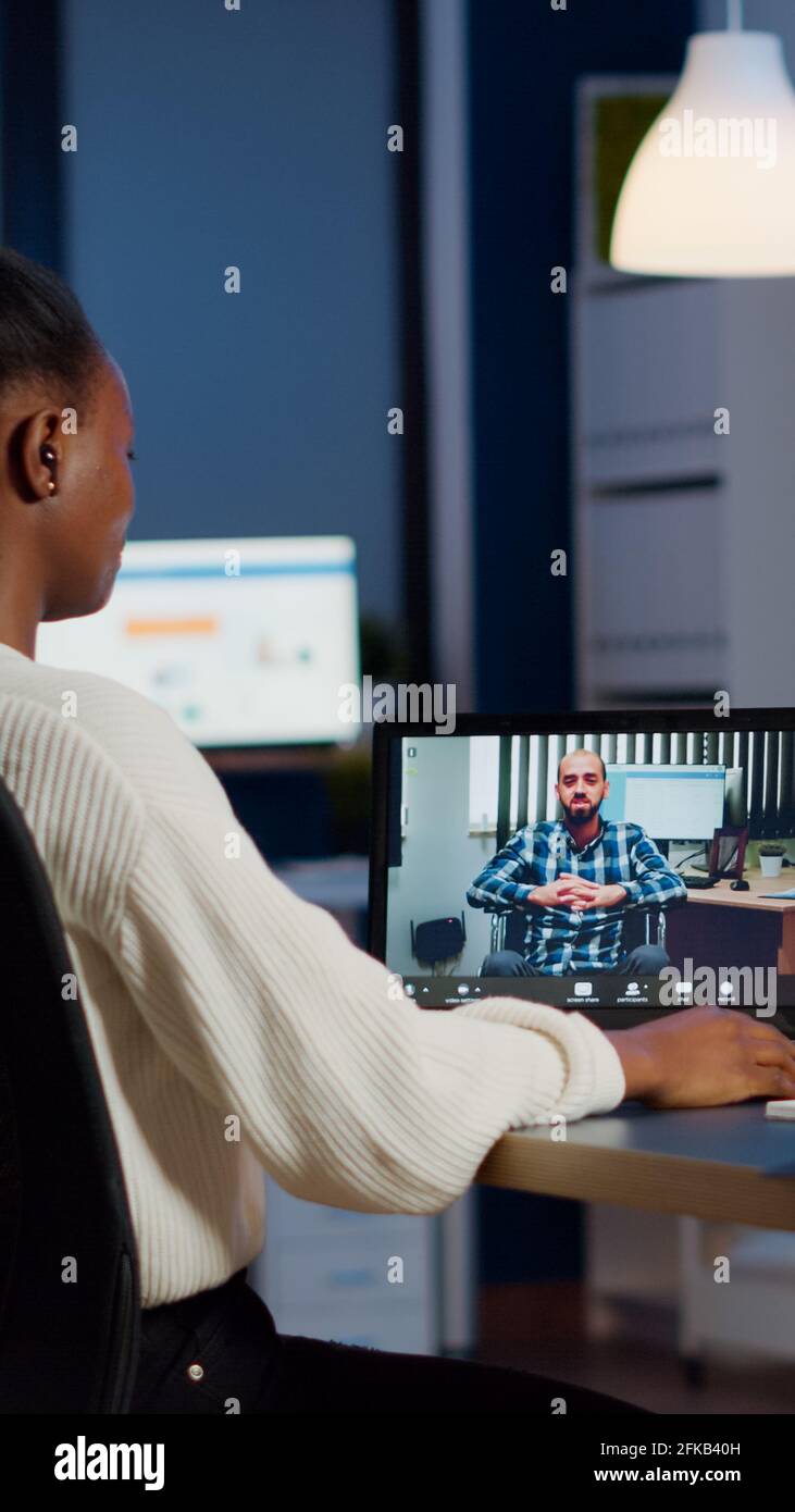 African manager with headphones waving at camera talking with remote ...
