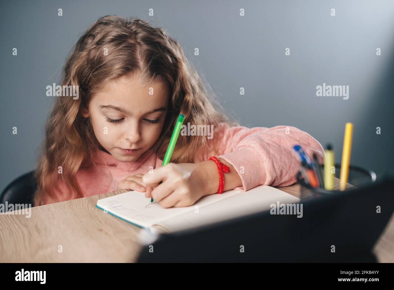 Close up photo of a caucasian blonde girl writing something during ...