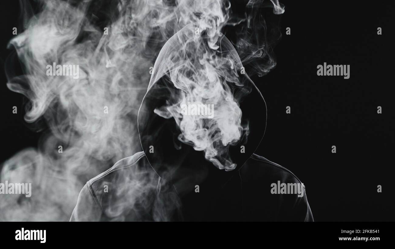 Smoker man in the hood in shadow Stock Photo - Alamy
