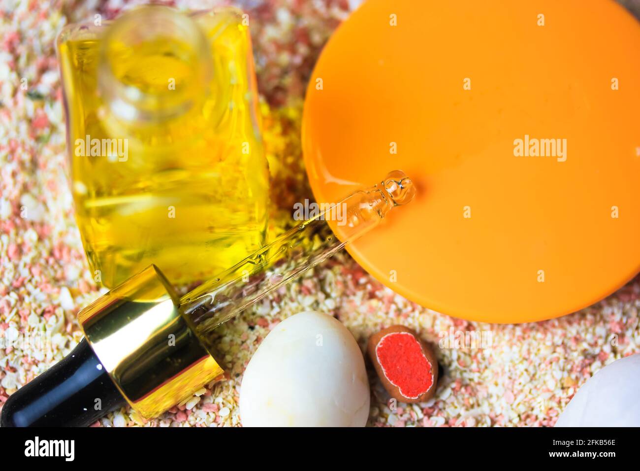 Dropper bottle, pipette with essential sunscreen oil on shells, sand ...