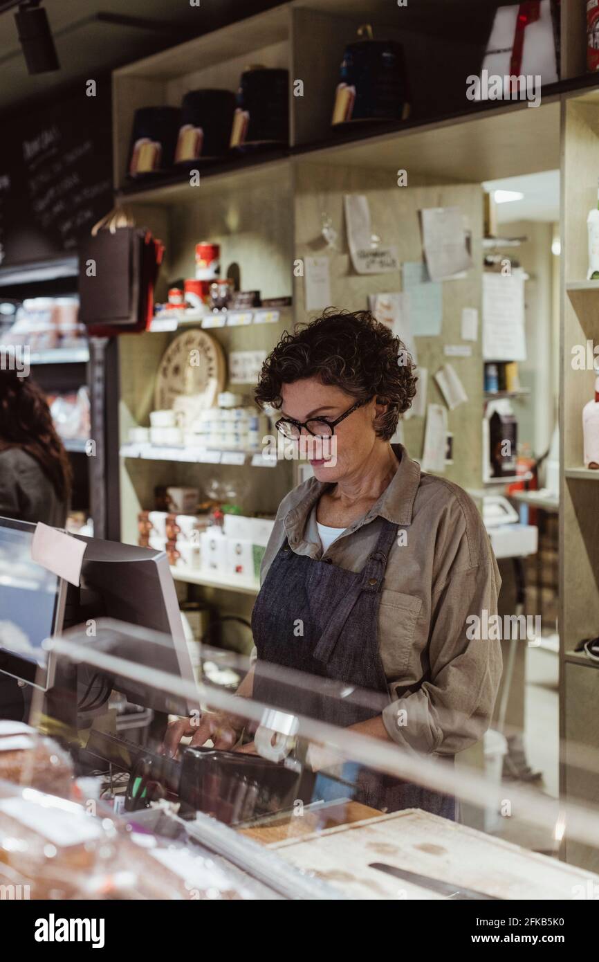 Female owner working in deli store Stock Photo - Alamy