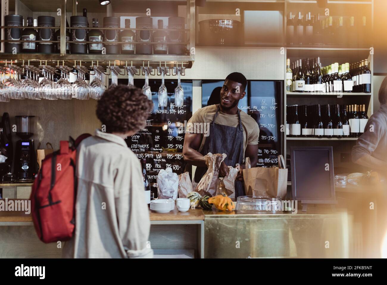 Female customer talking with male owner at delicatessen shop Stock ...