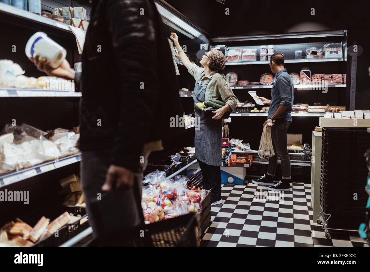 Male customers collecting package product while female owner standing ...