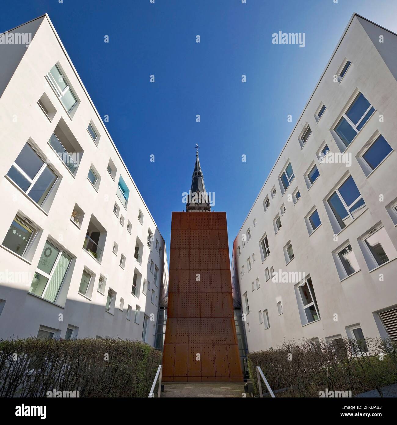 steeple of the Christuskirche behind modern apartment buildings ...