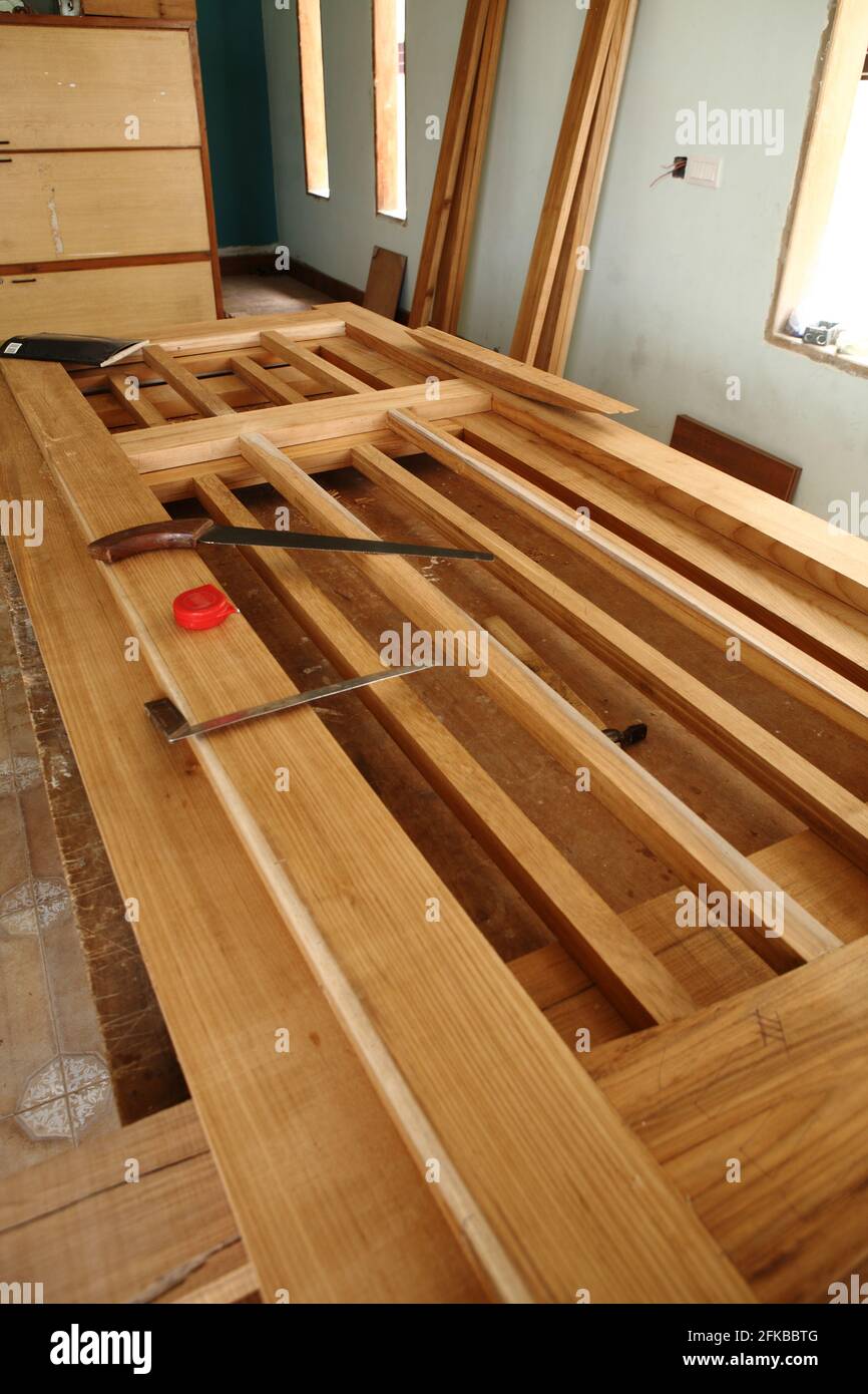 Panel door frame of teak wood is being made in a room of under ...
