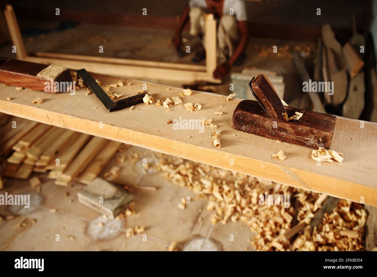 Carpenter is making a panel door frame of teak wood in a room of under ...